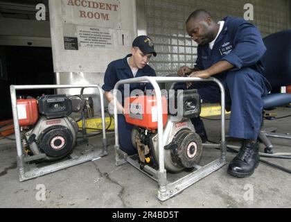 US Navy Damage Controlman 2nd Class shows children shipboard fire ...