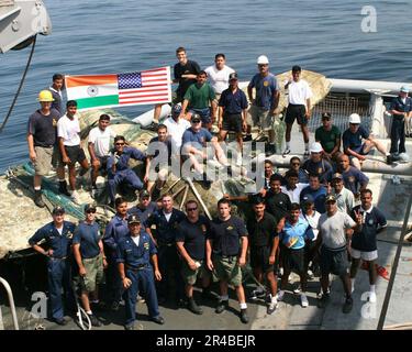 Crew members aboard the salvage ship USS PRESERVER (ARS-8) haul a piece ...