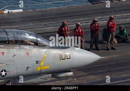 US Navy Aviation Ordnancemen wait with fork lifts as a Puma helicopter ...