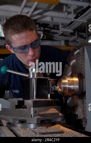US Navy Machinery Repairman Fireman re-sharpens a cold chisel in the ...