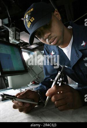 US Navy Quartermaster 3rd Class plots the course of the guided missile ...