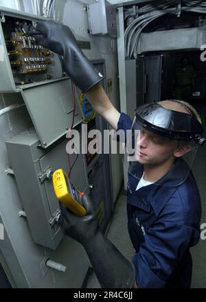 US Navy Electrician's Mate Fireman replaces a fuse in a switch panel ...