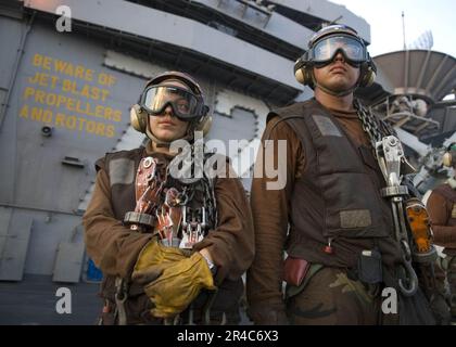 US Navy Plane Captains stand ready to direct the incoming F-14 Tomcats ...