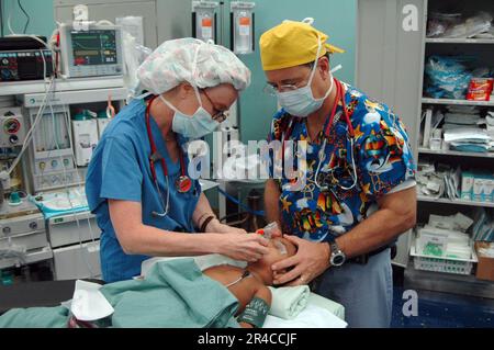 US Navy Operation Smile volunteers and Dr. anesthetize a young child ...