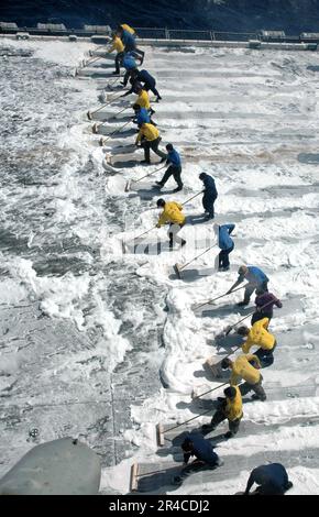 US Navy Sailors conduct a scrubbing exercise on the flight deck aboard ...