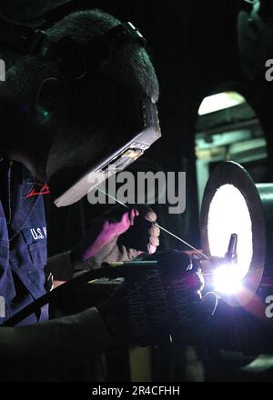 US Navy Hull Technician uses a grinder in he ships Stock Photo - Alamy