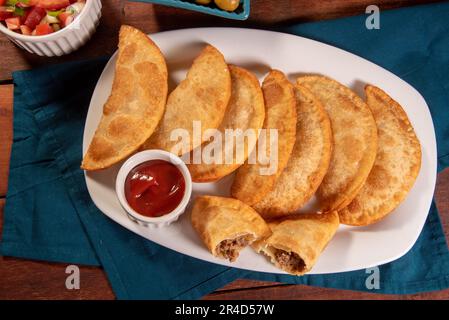 Fried Pastries, Pastel Frito Brasileiro, on wooden table. Pastel de ...