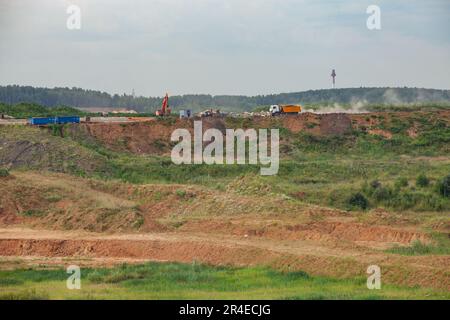 Landfill on quarry. Dump trucks unloads garbage. Dirt cloud over land ...