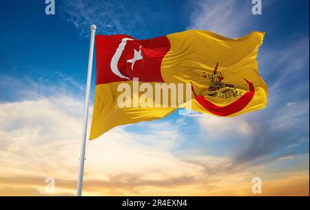 official flag of Selangor Malaysia at cloudy sky background on sunset, panoramic view. Malaysian ...