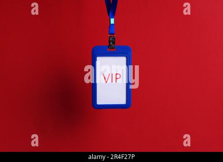 Blue plastic vip badge hanging on yellow background Stock Photo - Alamy