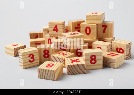 Wooden cubes with numbers and mathematical symbols on light background ...