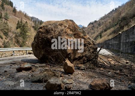 A huge rock fell from the mountains onto the road, destroying the ...