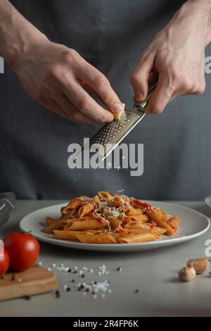 Man cooking pasta, grating cheese Stock Photo - Alamy