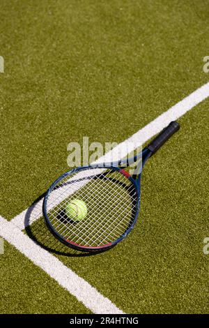 High angle view of tennis racket and ball by marking on grassy field at ...