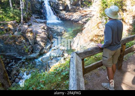 Hiker near beautiful waterfall in Canadian mountains Stock Photo - Alamy