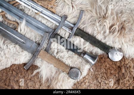 Medieval swords on sheep fur background Stock Photo - Alamy