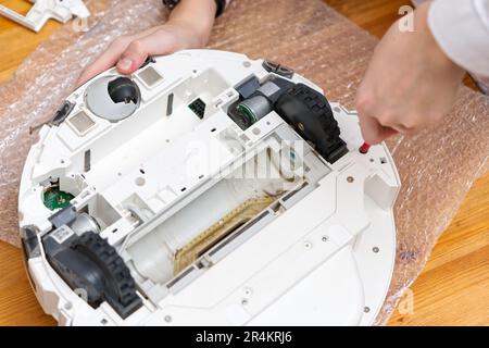 Serviceman, Repairman, maintenance on robotic vacuum cleaner. Repairing ...
