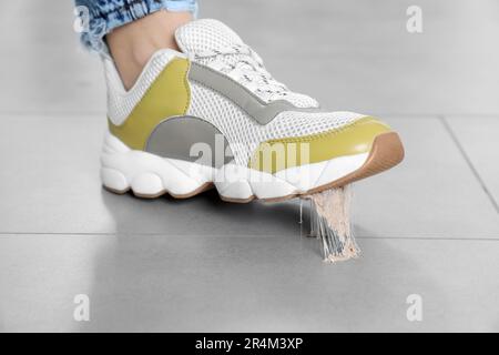 Person stepping into chewing gum on light blue background, closeup ...