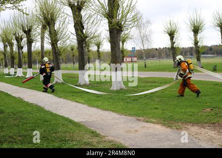 Professional firefighters, rescuers in protective fireproof suits ...