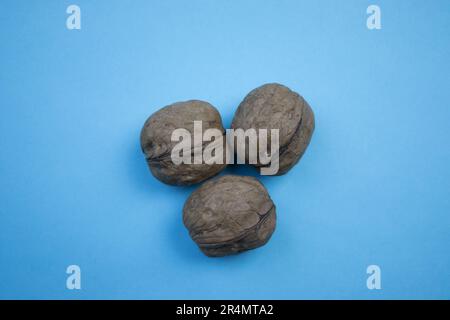 Three walnuts in shell, photographed from above, placed on the edge of ...