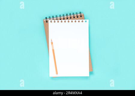 Blank spiral notebook with pencil turquoise background Stock Photo - Alamy