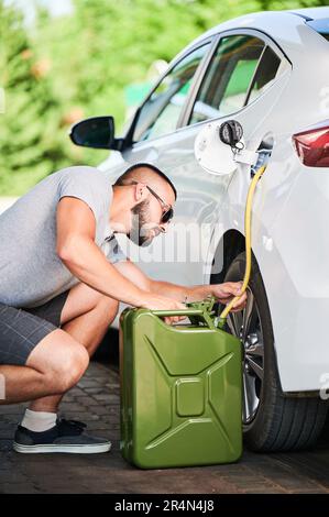 Weird man pumping gasoline from a gas tank into canister. Self ...