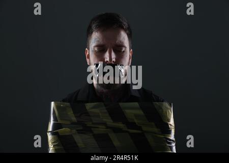 Man taped up and taken hostage on dark background Stock Photo - Alamy