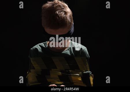 Little boy tied up and taken hostage on dark background Stock Photo - Alamy