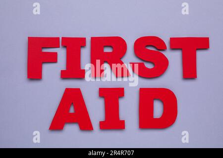 Words First Aid made of red letters and pills on grey background, flat ...