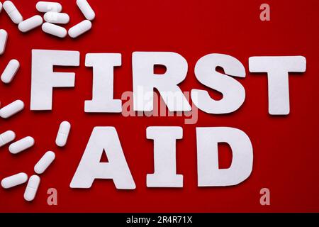 Words First Aid made of white letters and cardboard heart on light blue ...