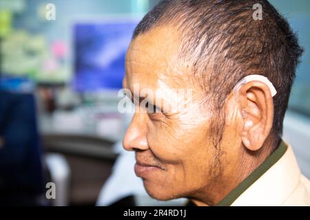 An old man wears a hearing aid, closeup Stock Photo - Alamy