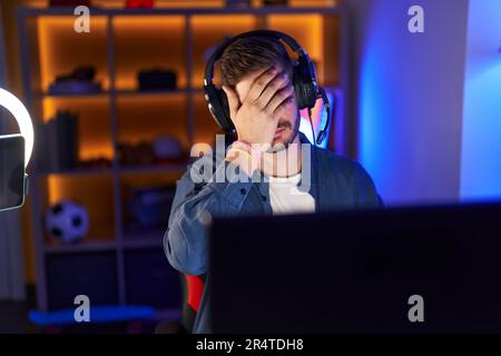 Young caucasian man streamer stressed using computer at gaming room ...