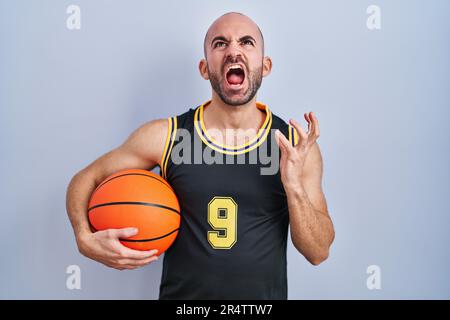 Emotional sportsman, basketball player shouting holding ball and ...