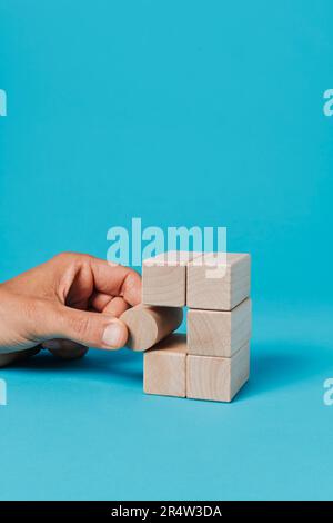 a cylindrical toy block in a stack of rectangular toy blocks, on a blue ...