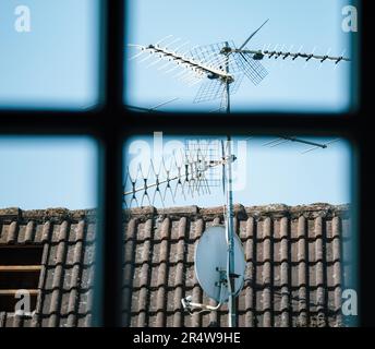 A stunning view of a blue-tiled roof filled with diverse antennas seen ...