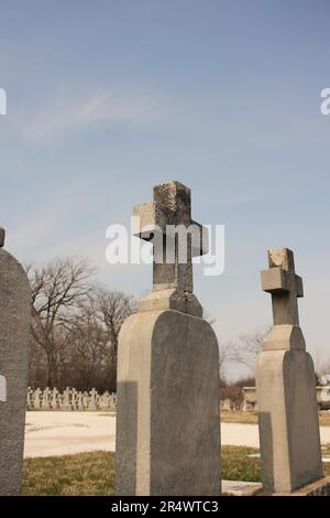 Simple plain stone cross standing in the sunny cemetery in a black and ...