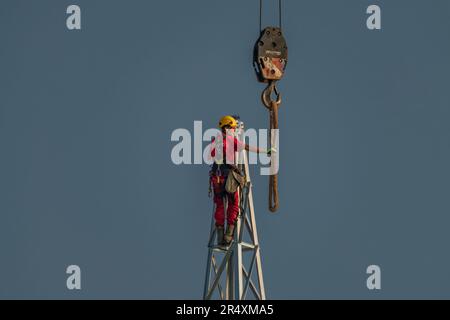 New truss electricity pole with male design engineer with crane and ...