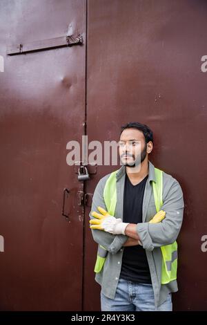 Indian worker in high visibility vest and gloves talking to smiling ...