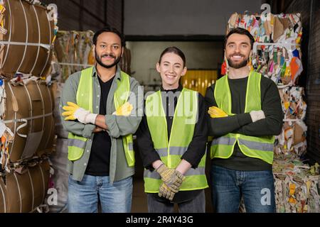 Multiethnic workers in high visibility vests and gloves separating ...