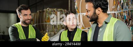 Bearded indian sorter in glove and high visibility vest putting paper ...