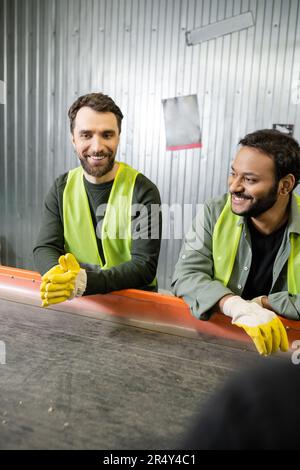 Cheerful multiethnic sorters in high visibility vests and gloves ...