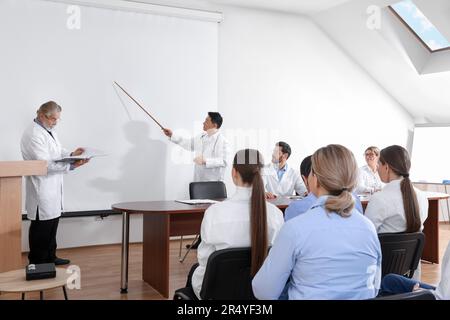 Doctors giving lecture near projection screen in conference room Stock ...