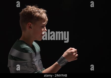 Victim boy with hands tied up with rope in emotional stress and pain ...