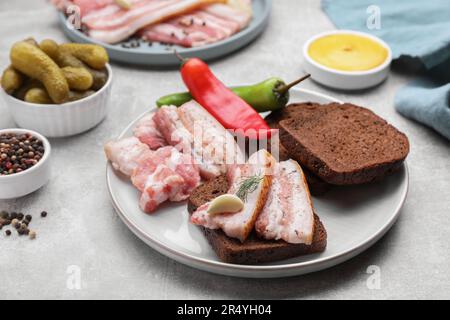 pork fatback with spices, rye bread and pickled cucumbers on black ...