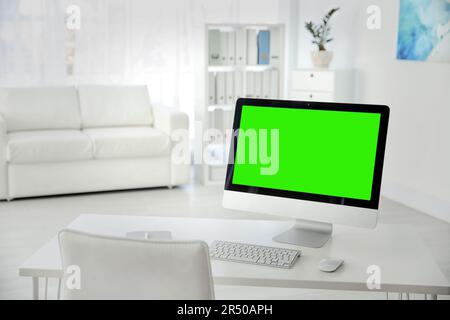 Computer display with chroma key on desk in room. Comfortable workplace ...