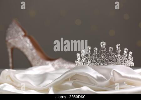 Beautiful silver tiara with diamonds near shoe on white cloth Stock ...