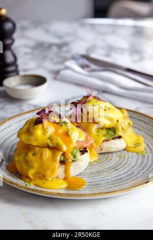 Egg Benedict with english muffin, soft cheese, ham, tomato, basil ...