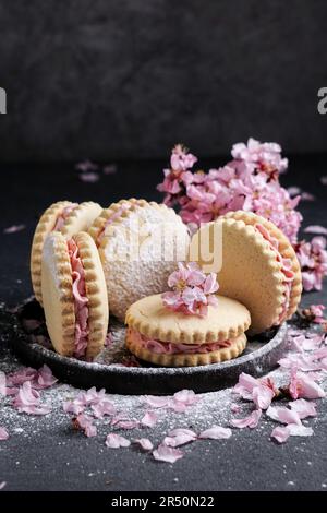 Delicious Argentinian cookies alfajores with cream on paper close-up on ...