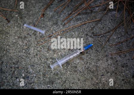 Disposable syringe with needle on stone surface outdoors, flat lay ...