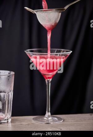 Making Cosmopolitan cocktail, pouring cranberry juice in a glass Stock ...